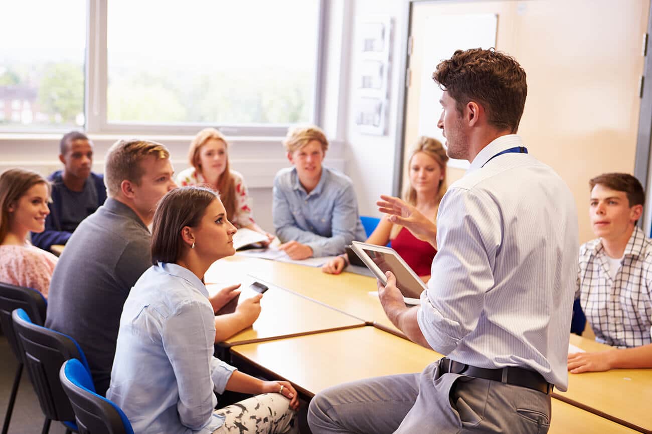 Teacher With College Students Giving Lesson In Classroom - rkmagazin.sk